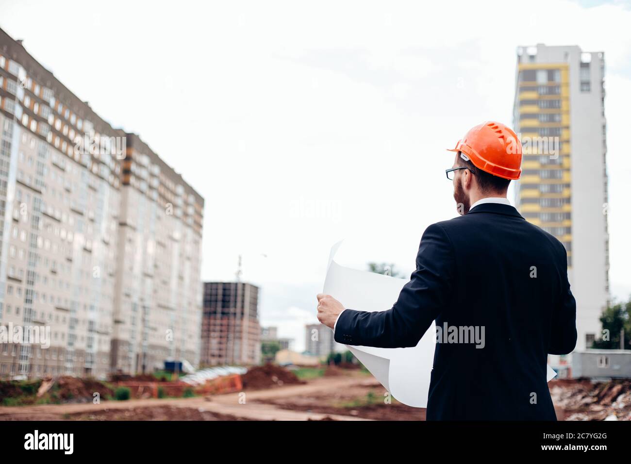 Portrait of an architect builder studying layout plan of the rooms ...
