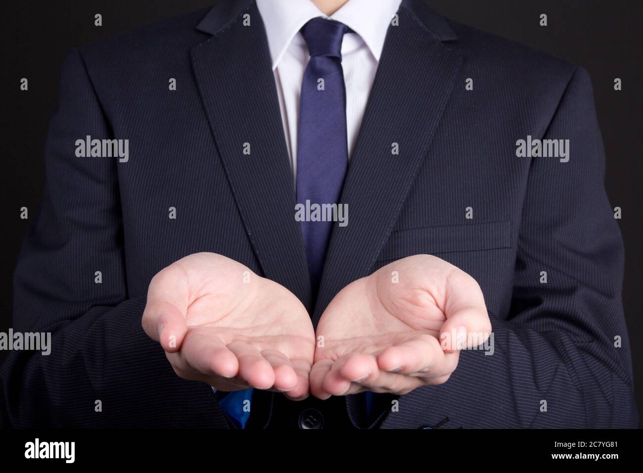business man holding hand presenting product over dark background Stock ...