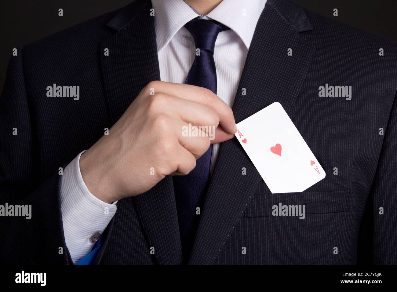 mans hand hiding playing card in business suit pocket Stock Photo - Alamy