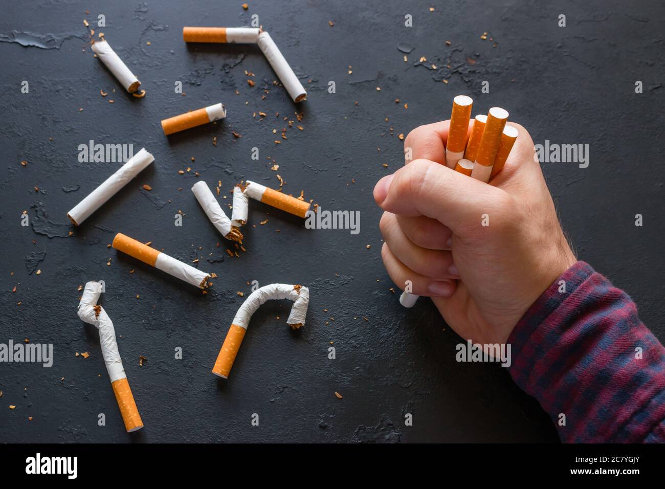 Man squeezes cigarettes in fist - stop smoking Stock Photo - Alamy
