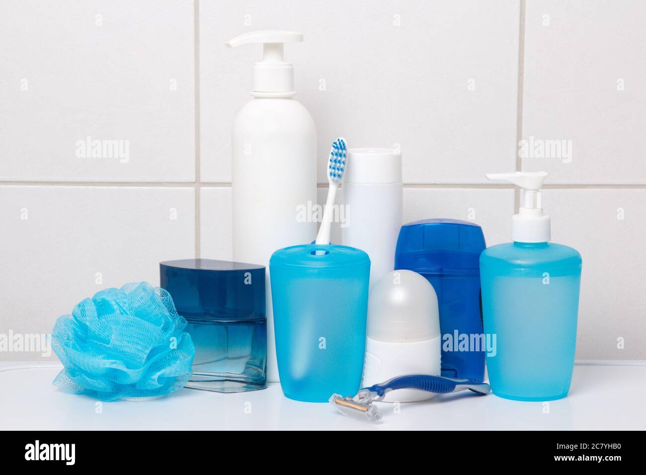blue male hygiene supplies over white tiled wall in bathroom Stock ...