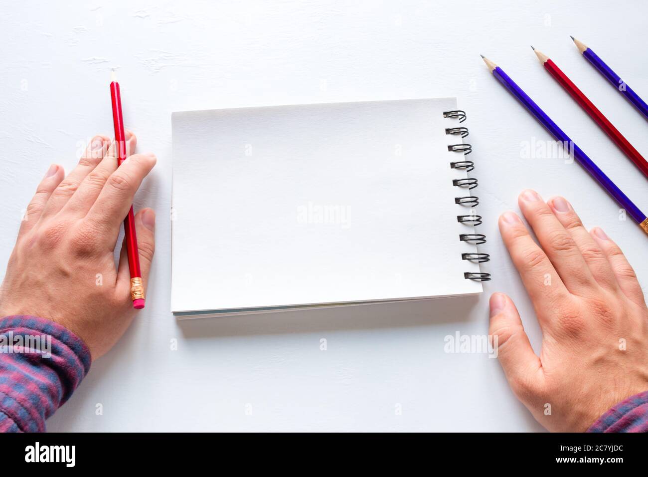 Left-handed man with a pencil in his hand and a notebook with space for ...