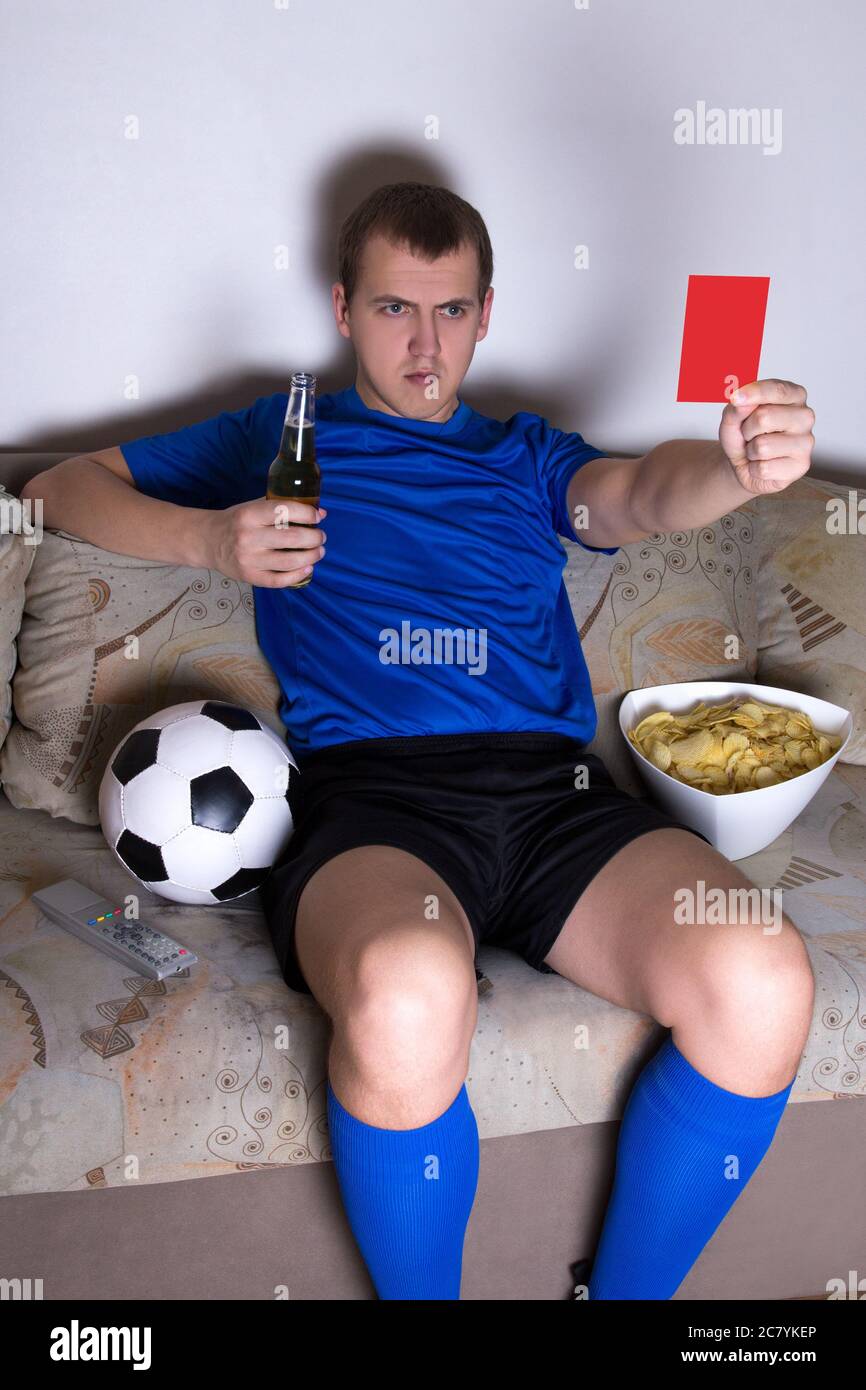 young attractive man watching football on tv at home and showing ...