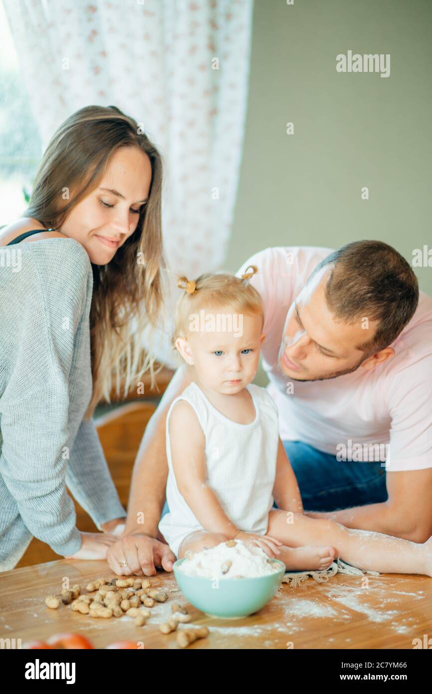 Smiling young parents and their child are very happy, they are at home ...