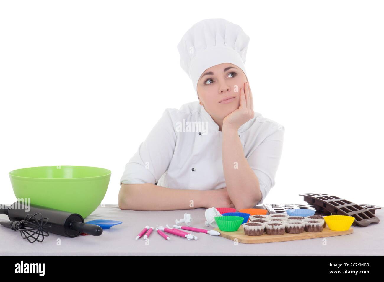 attractive bored female confectioner in cook uniform sitting at the ...