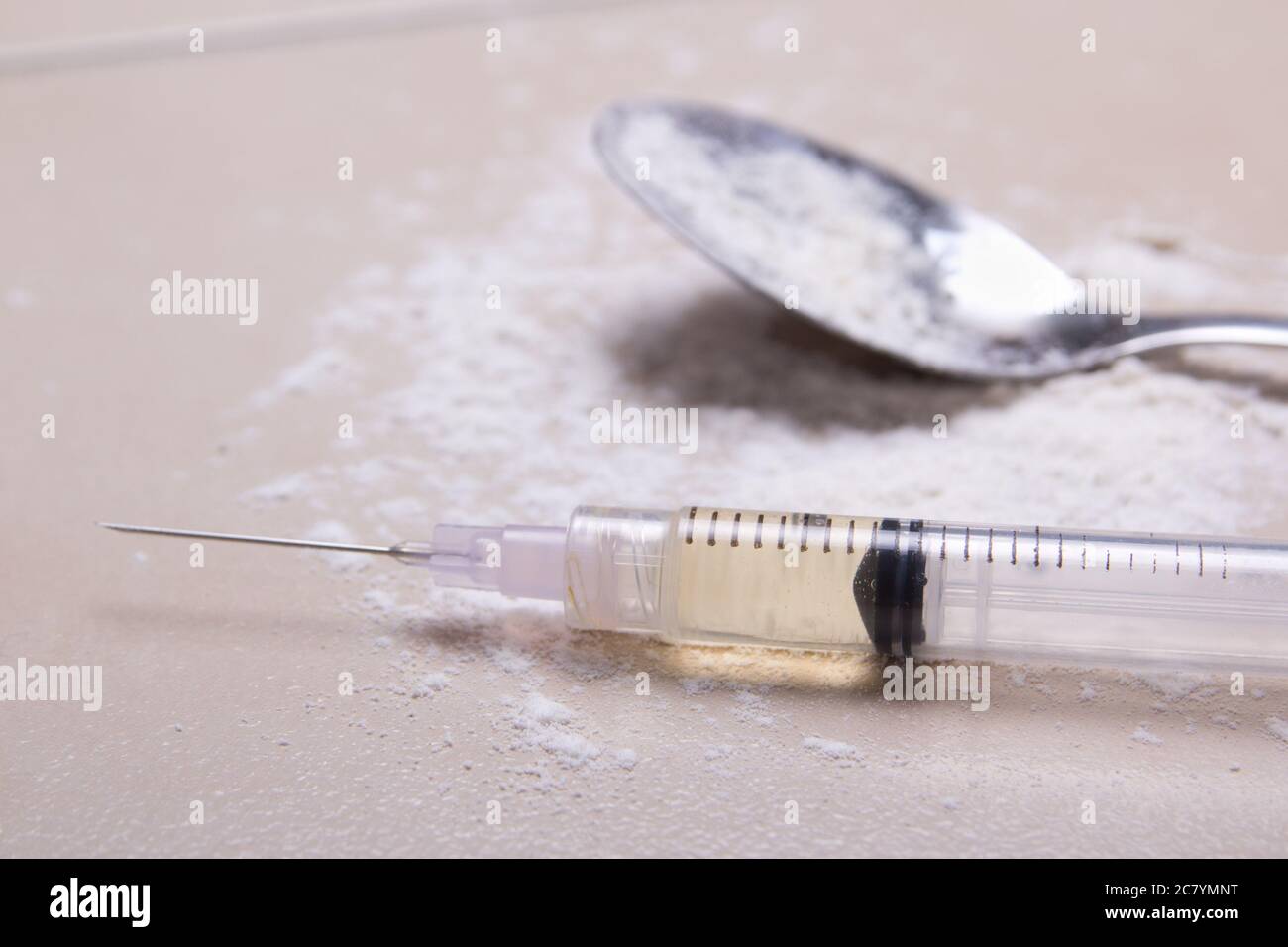 syringe with drug substance, heroin powder and spoon on tiled floor ...