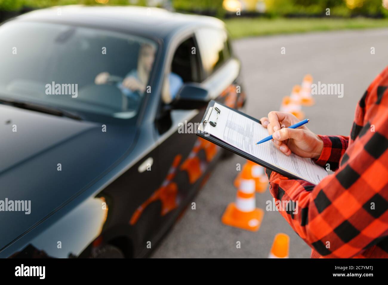 Instructor with checklist and woman in car, exam Stock Photo - Alamy