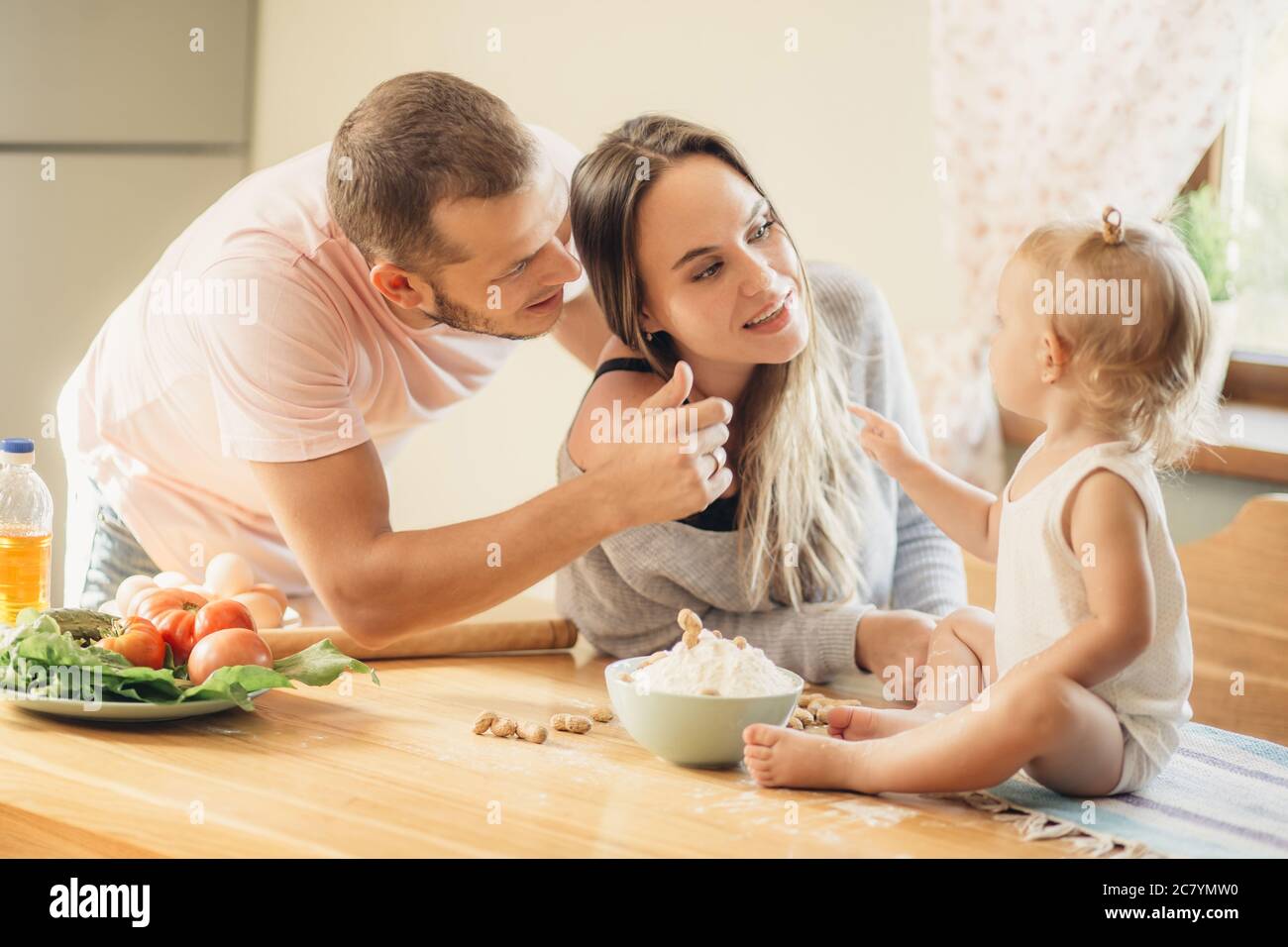 Smiling young parents and their child are very happy, they are at home ...