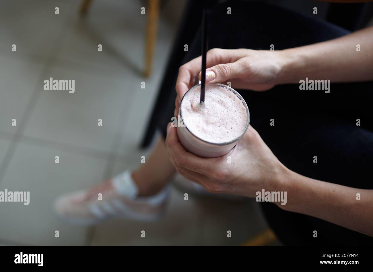 Woman holding milkshake cocktail in cafe.Relaxation mood.Blurred image ...
