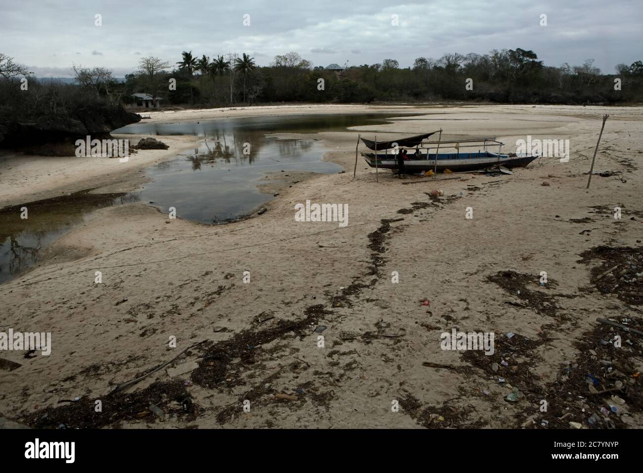 A fishing boat on intertidal beach during low tide in Waikelo ...