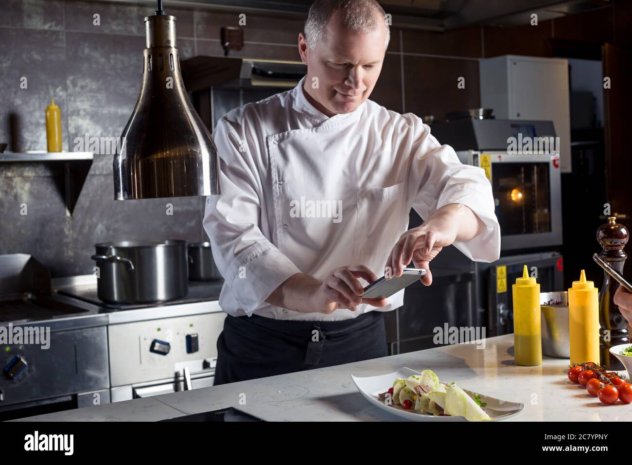 chef shooting with his cell phone camera his cooked food Stock Photo ...
