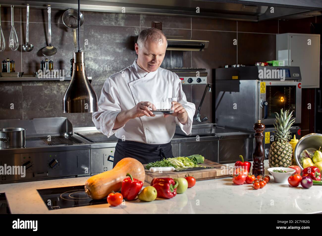 chef shooting with his cell phone camera his cooked food Stock Photo ...
