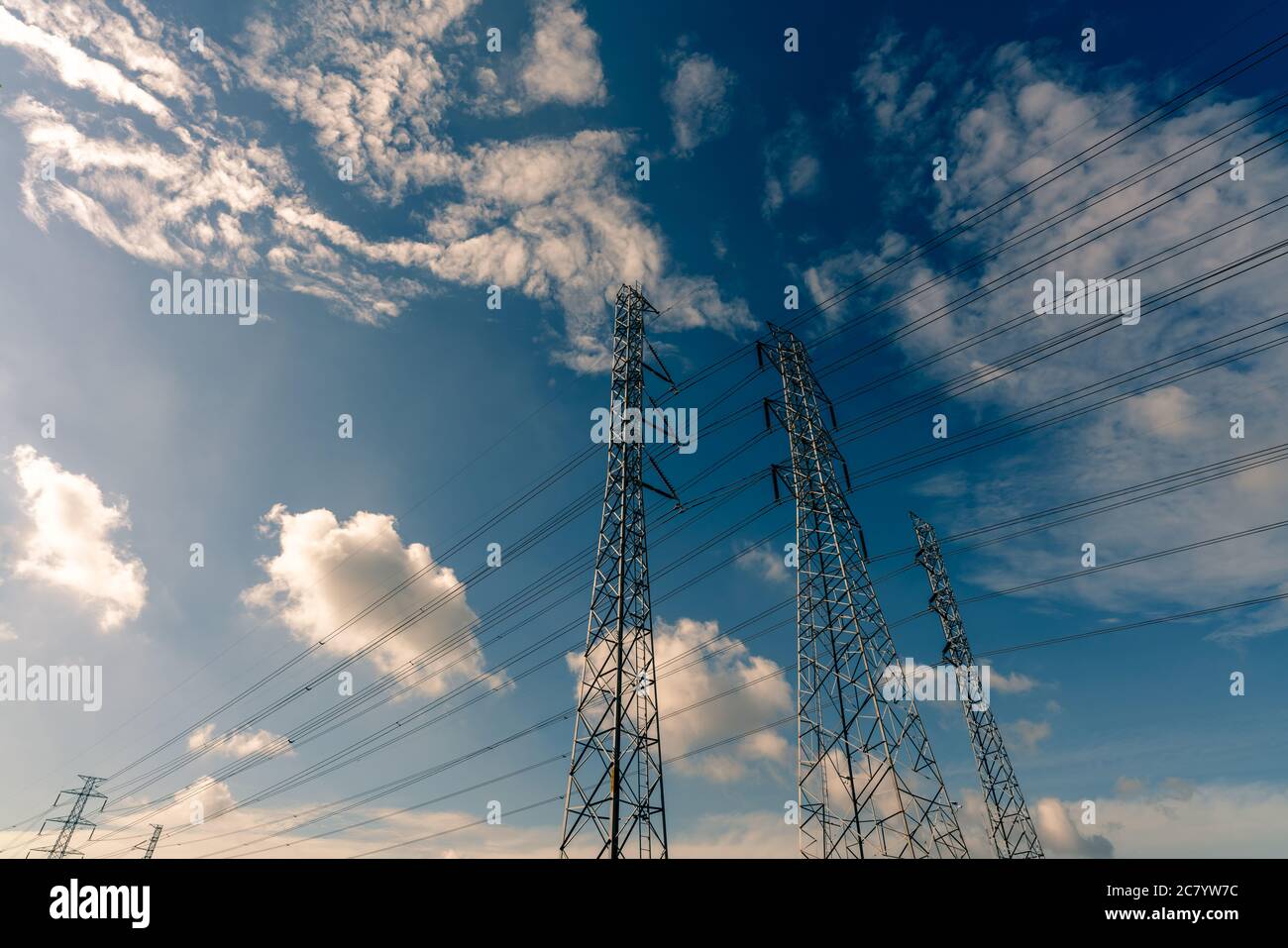 High voltage electric pylon and electrical wire against blue sky and ...
