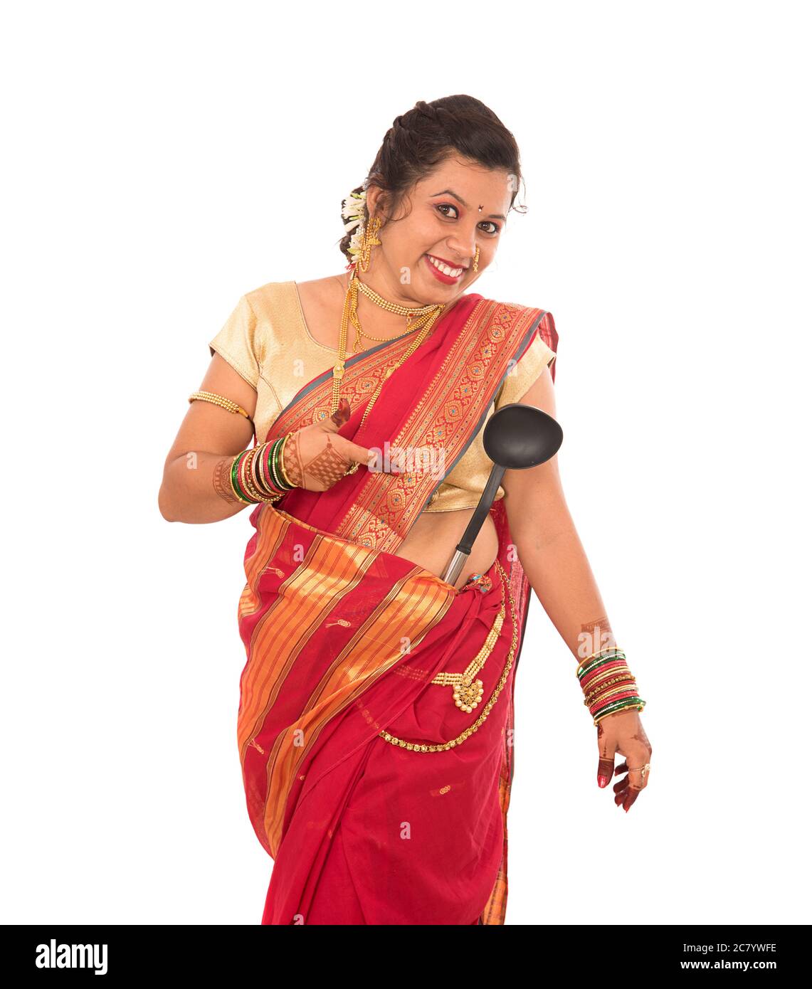 Young Traditional Indian Girl holding kitchen utensil on white ...