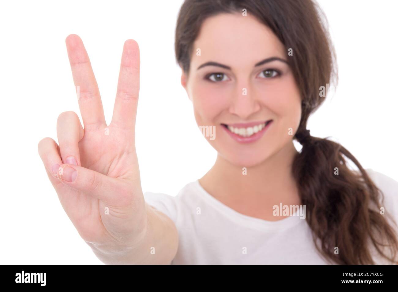 portrait of happy young woman giving peace sign isolated on white ...