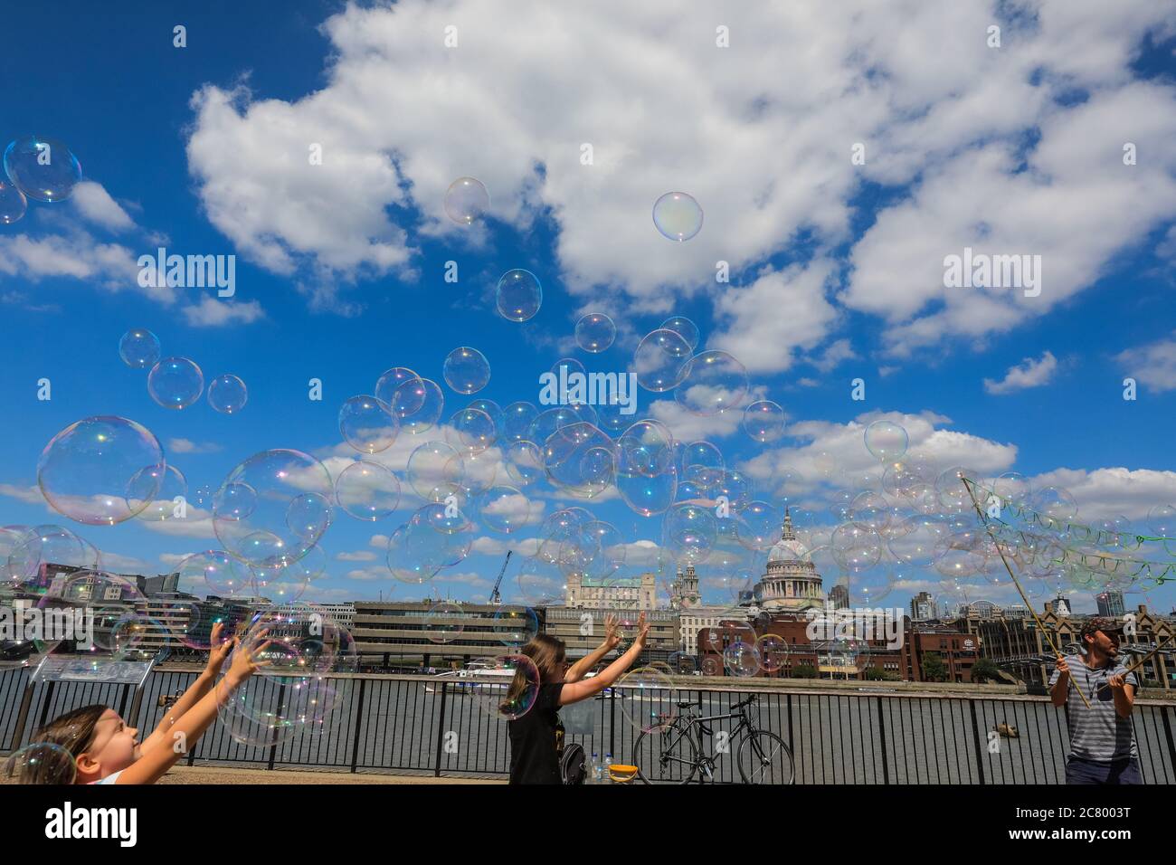A soap bubble artist entertains people with giant bubbles, St Paul's ...