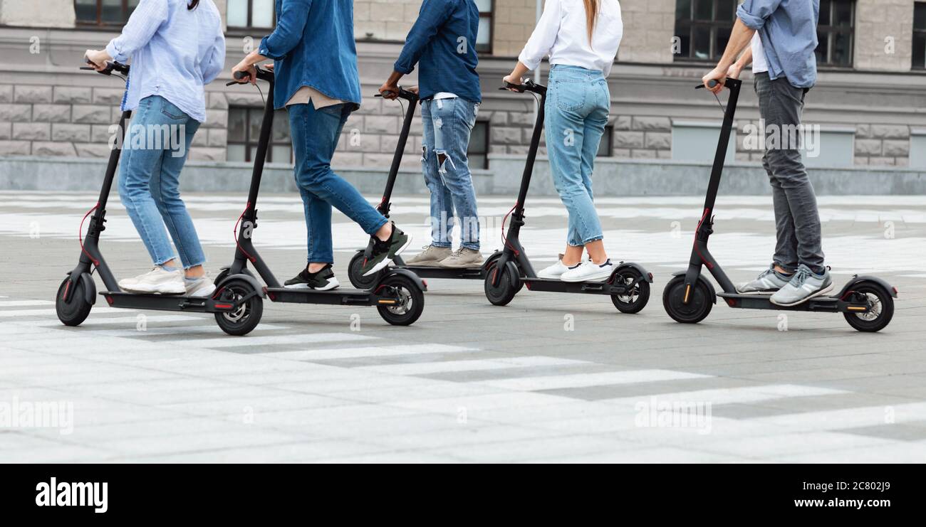 Friends having ride on motorized kick scooters Stock Photo - Alamy