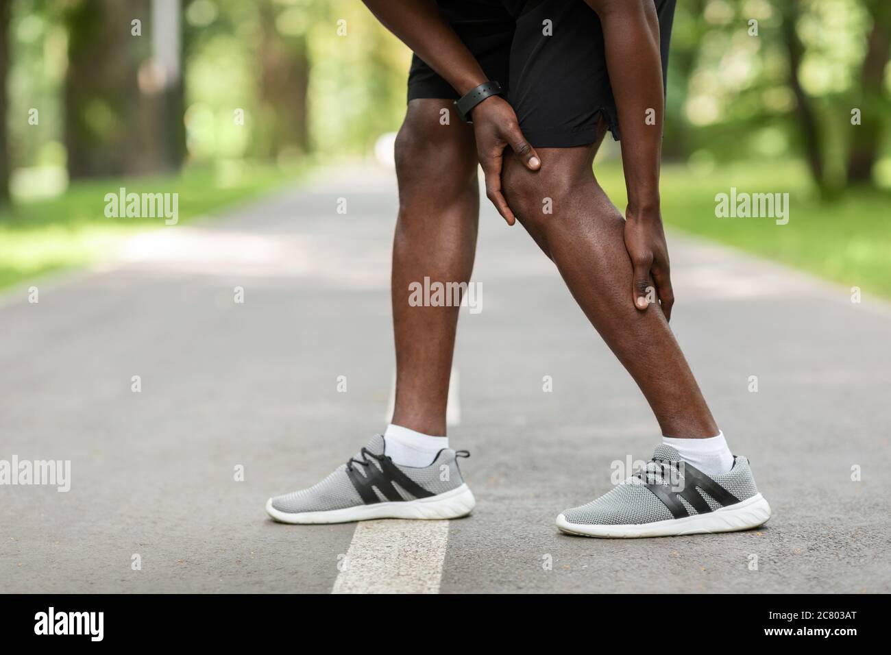 African guy rubbing his aching leg, got cramp while jogging Stock Photo ...