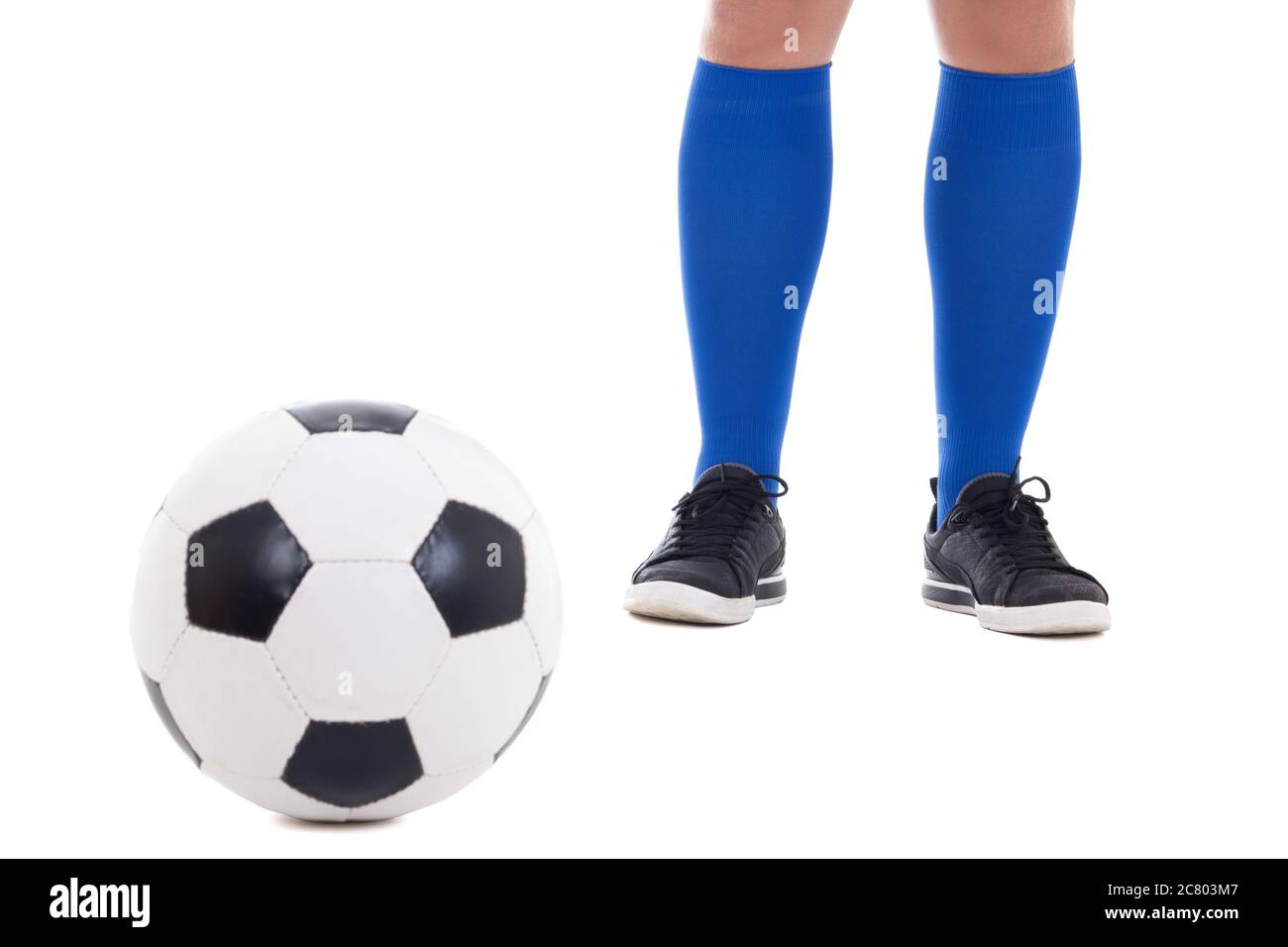 legs of soccer player in blue gaiters with ball isolated on white ...
