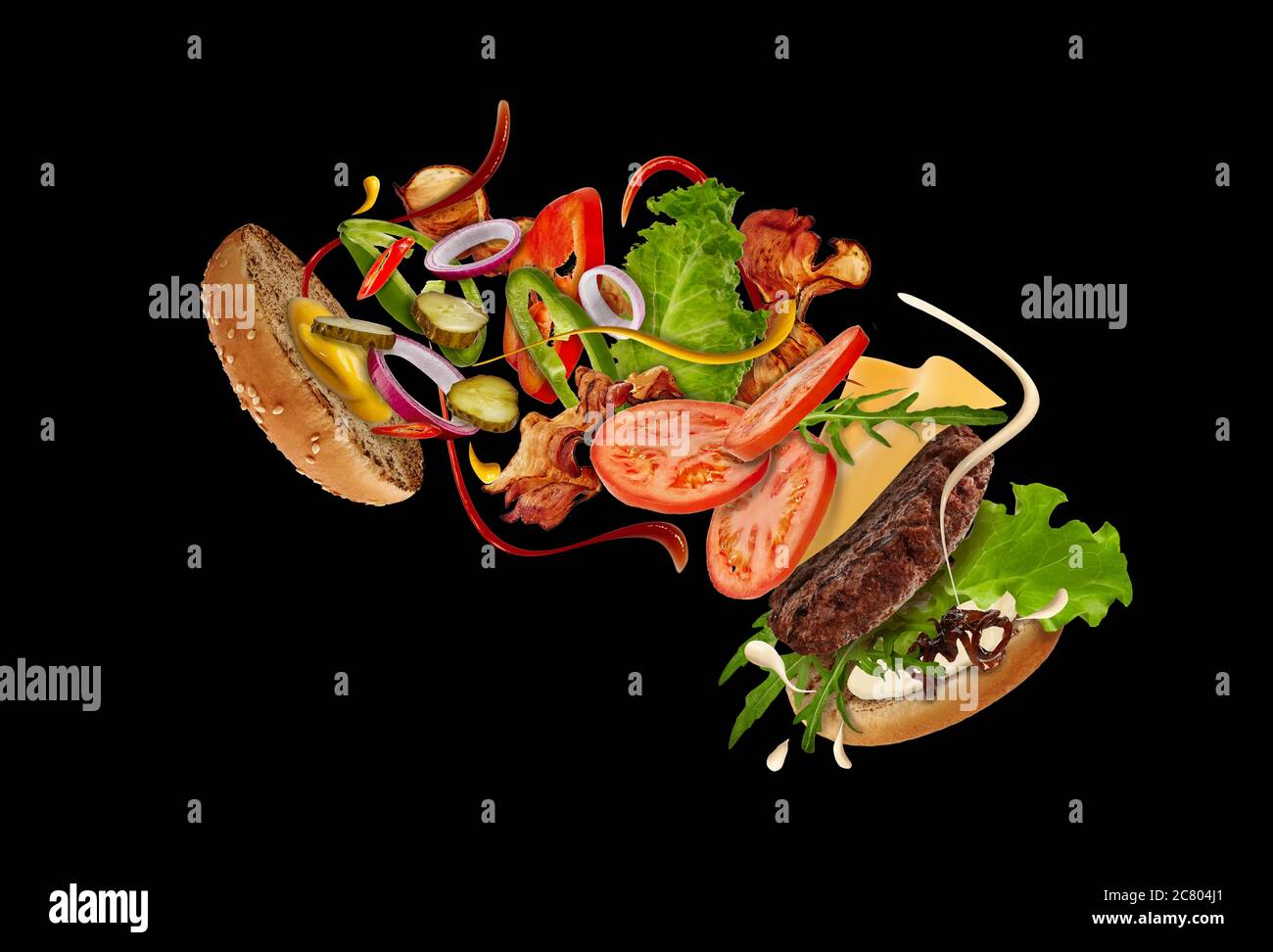Big burger with flying ingredients on black background. Ham, beef ...