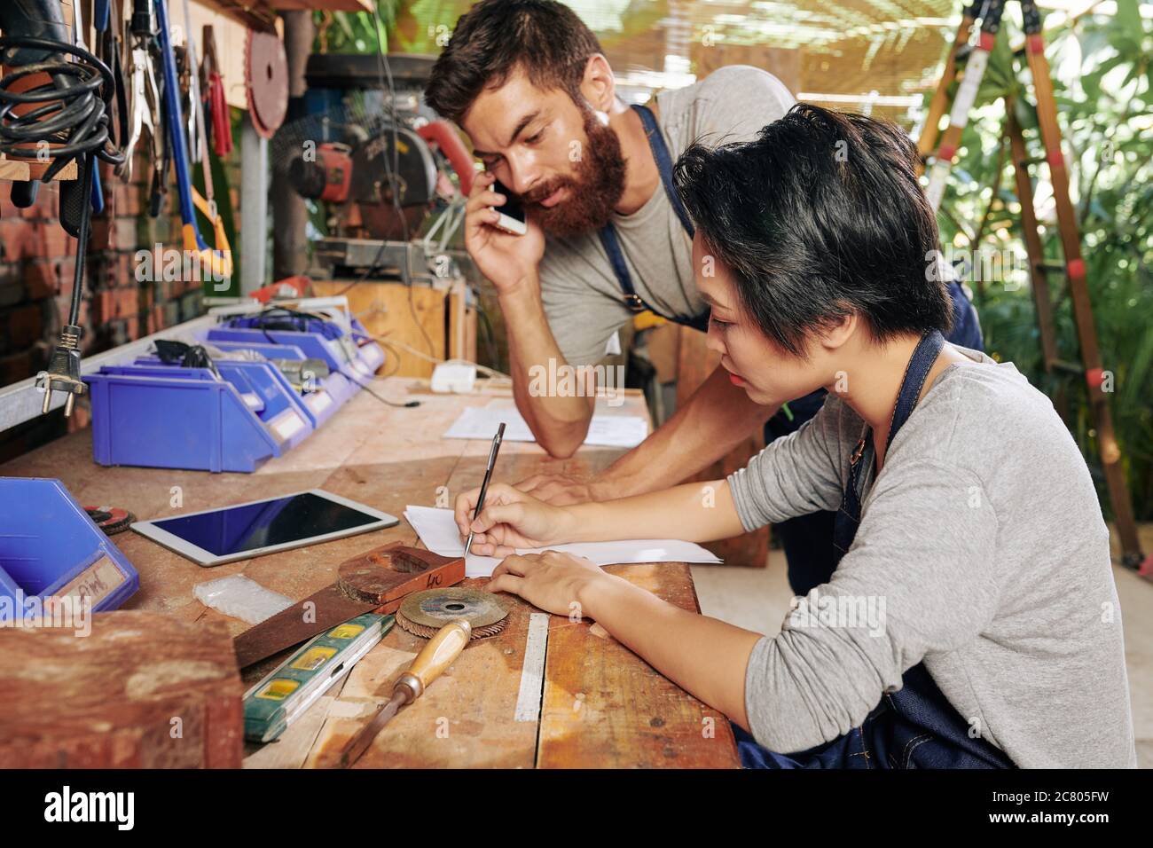 Carpenter talking on phone with customer when his female colleague ...