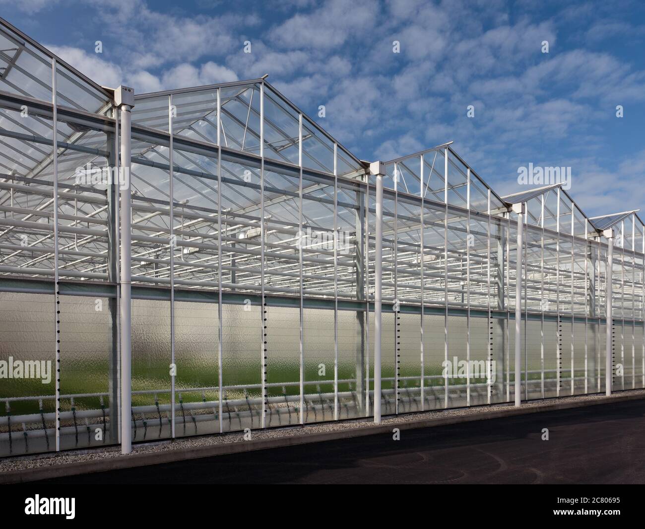 Sideview of a new greenhouse against a blue sky Stock Photo - Alamy
