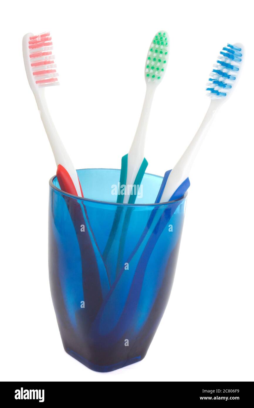 colorful toothbrushes in blue glass over white Stock Photo - Alamy