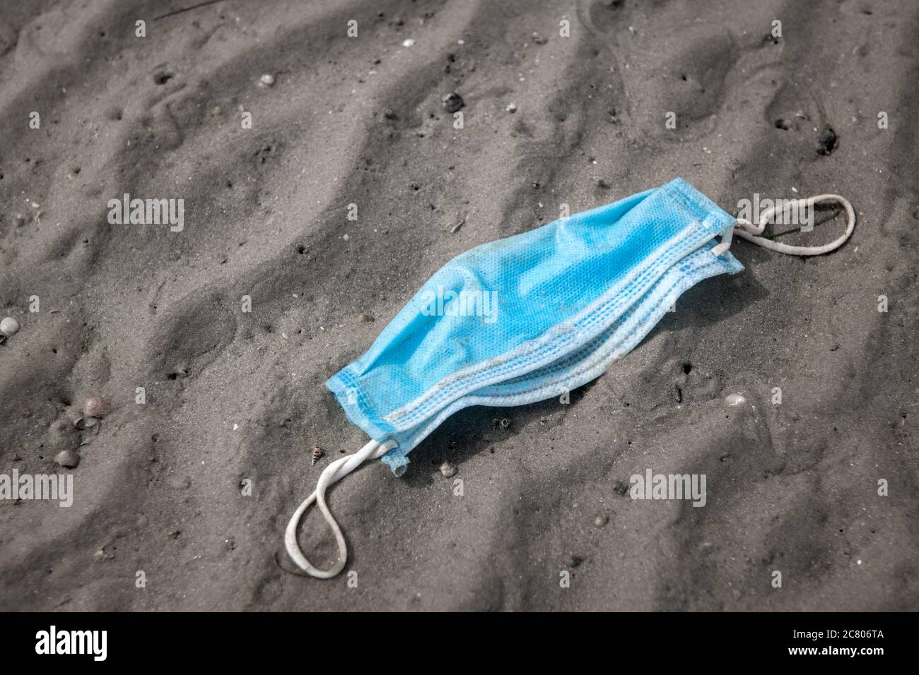 Used face mask dirty waste on the beach with outdoor sun lighting Stock ...