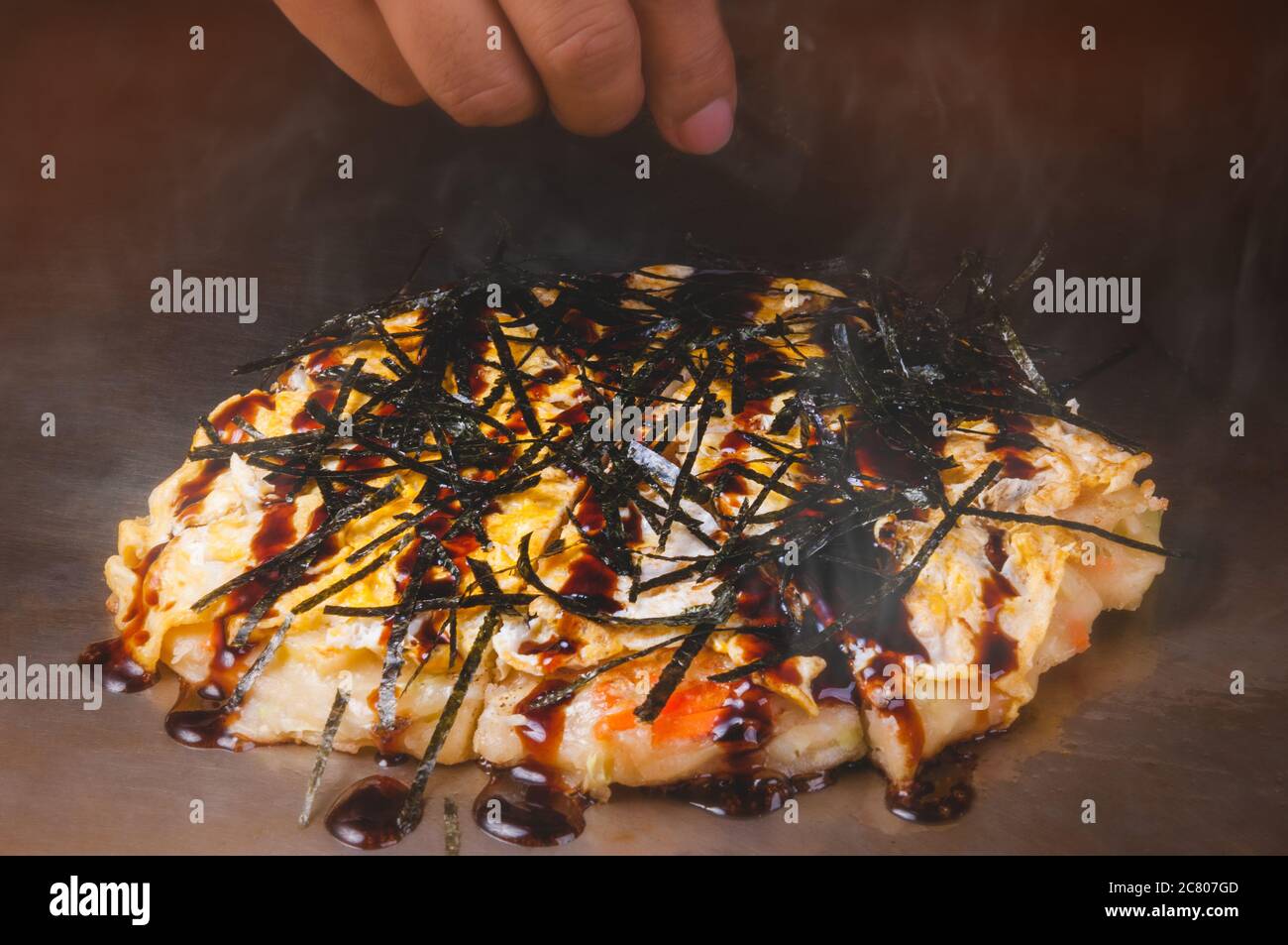 Japanese pizza okonomiyaki cooking on hot plate teppanyaki style Stock ...