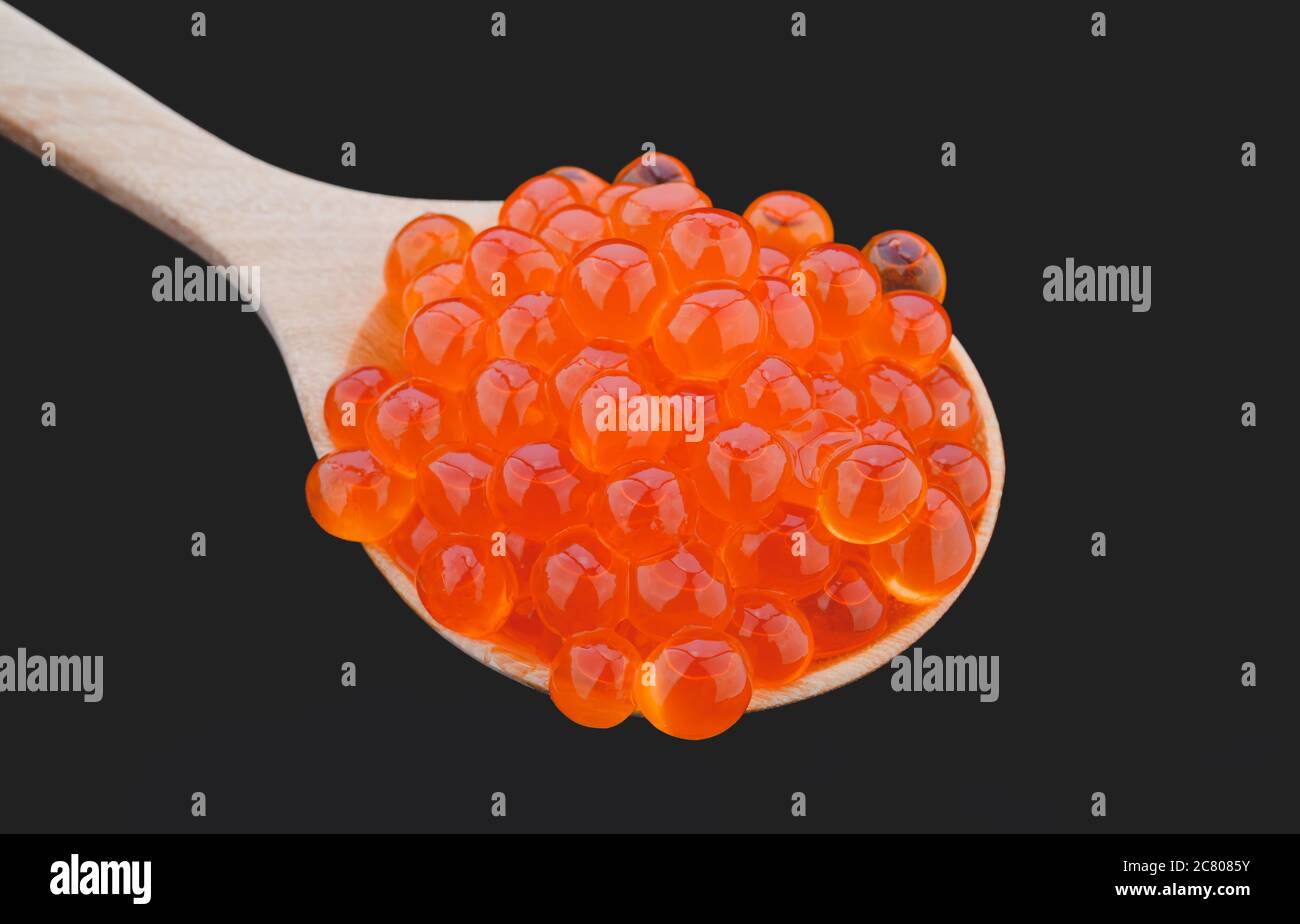 Salmon roe in wooden spoon with black background Stock Photo - Alamy