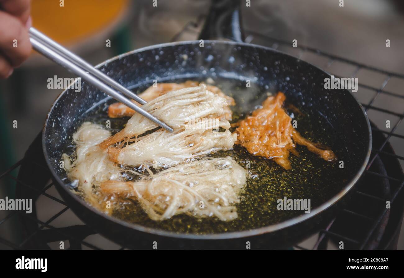 Frying crispy enoki mushroom with cooking oil Stock Photo - Alamy