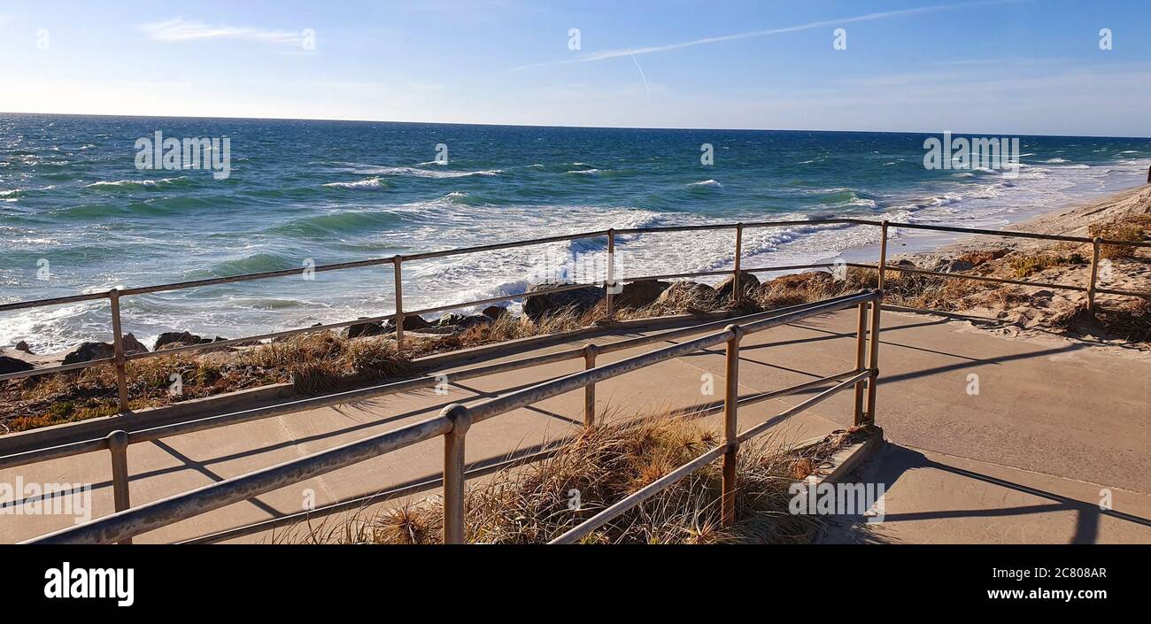 High angle shot of the wavy beach captured from a walking path on the ...