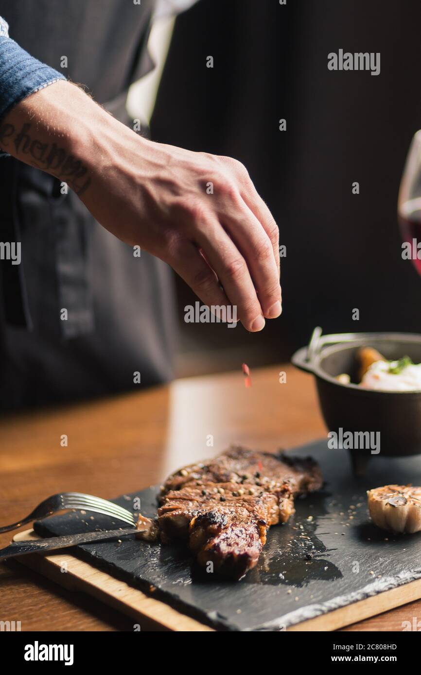 Chef in hotel or restaurant kitchen cooking, only hands. He is working ...