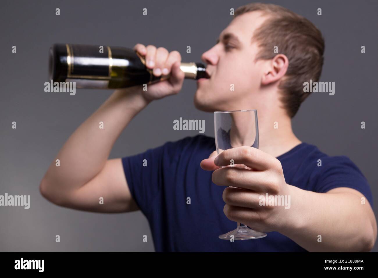 man drinking alcohol over grey background Stock Photo - Alamy