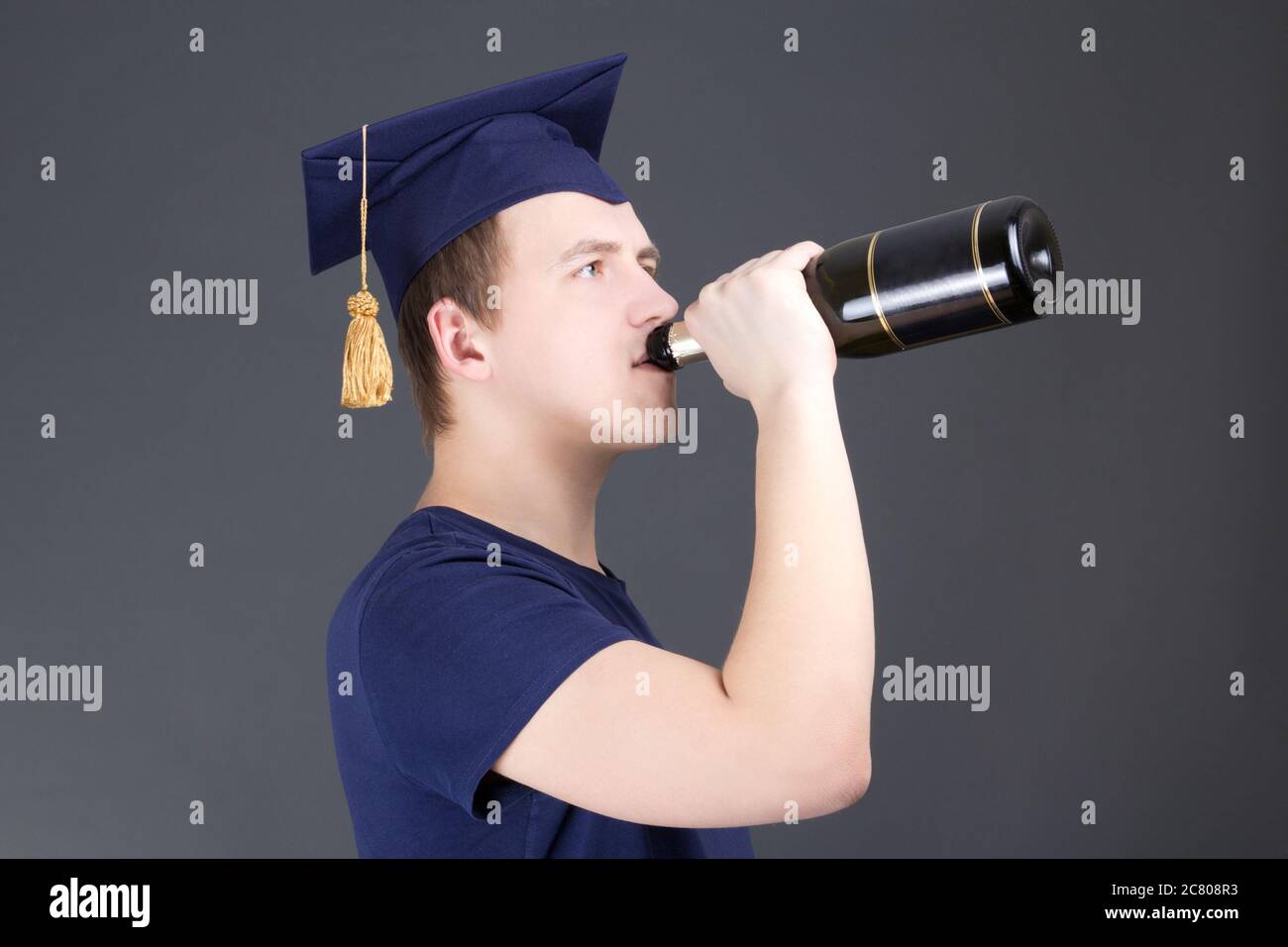 young graduation man drinking champagne over grey background Stock ...
