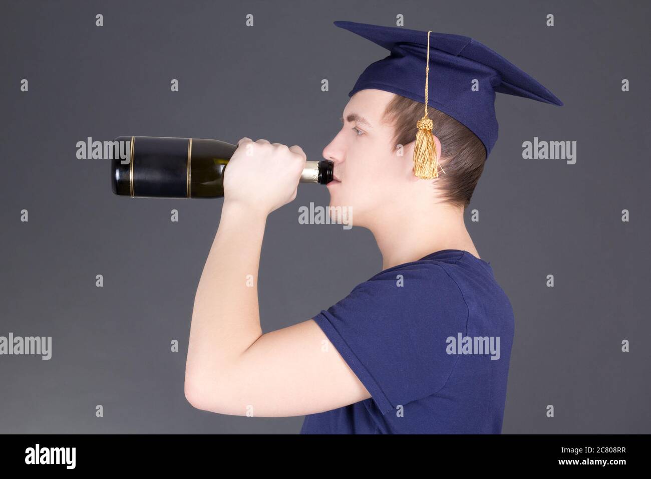 graduation man drinking champagne over grey background Stock Photo - Alamy