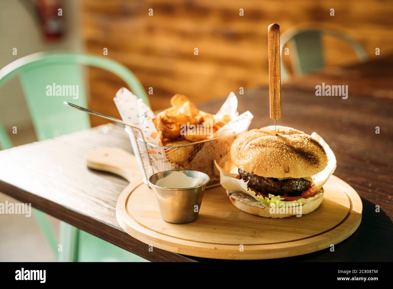 Delicious meet burger, fries and sauce served on wooden planks Stock ...