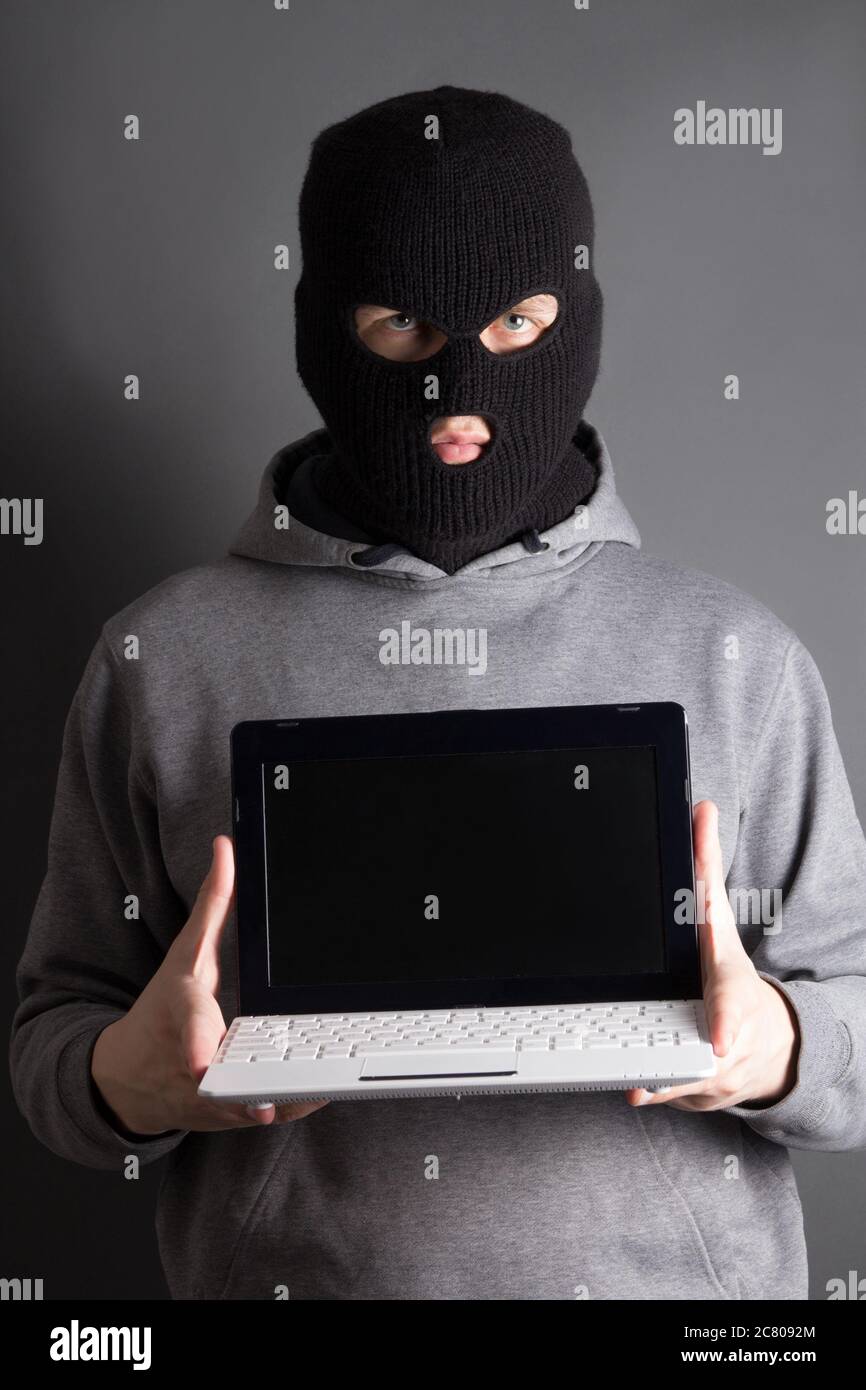 masked man with laptop over grey Stock Photo - Alamy