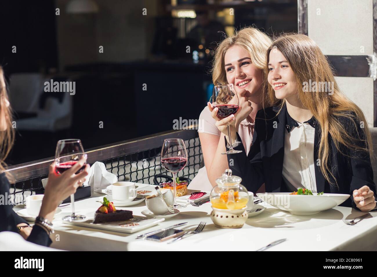 Girls having fun. Best friends hanging out and eating at restaurant ...