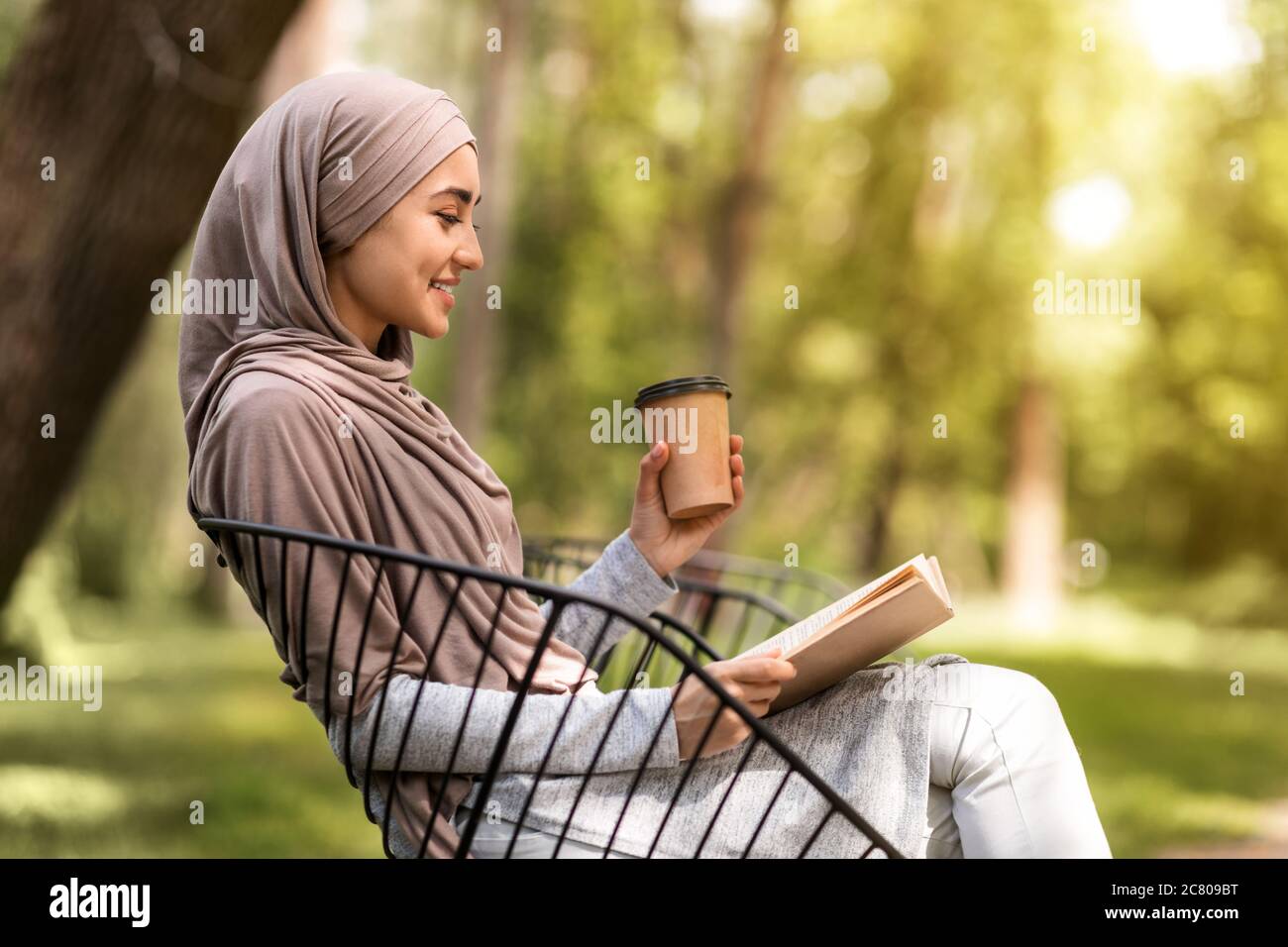 Profile photo of arab girl reading book at city park Stock Photo - Alamy
