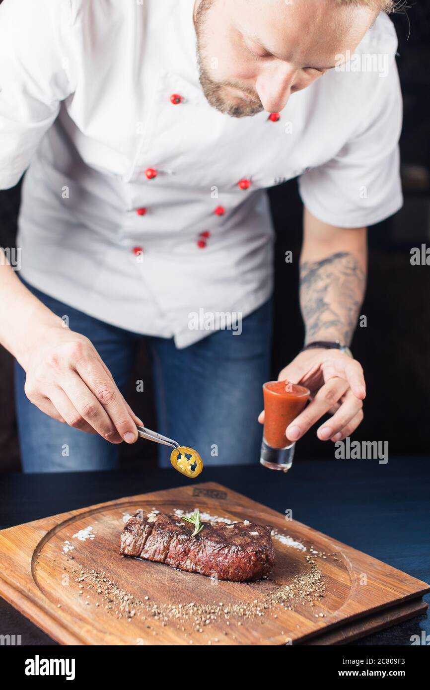 Chef finishing her plate and almost ready to serve at the table. Only ...