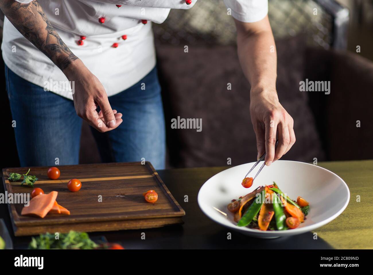 Chef finishing her plate and almost ready to serve at the table. Only ...