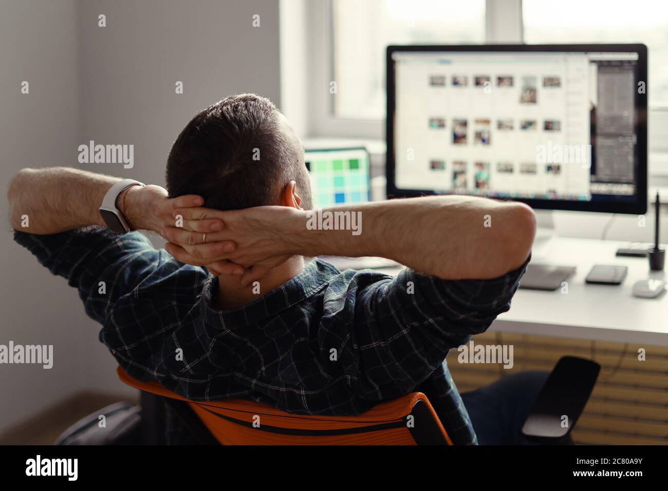 Man relaxing while working remotely from home looking at the computer ...