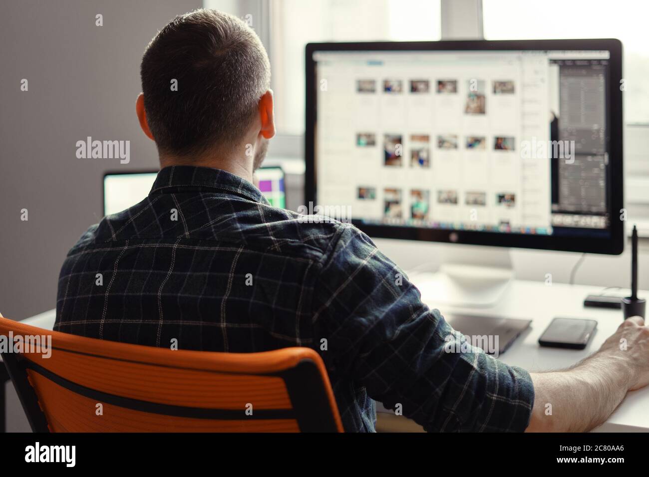 Back view freelancer man working remotely from home. Young male working ...