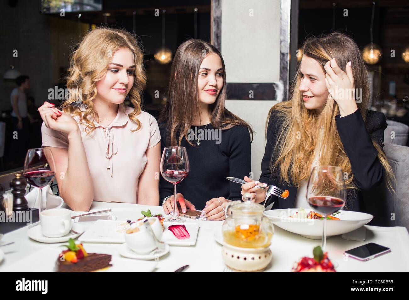 Girls having fun. Best friends hanging out and eating at restaurant ...