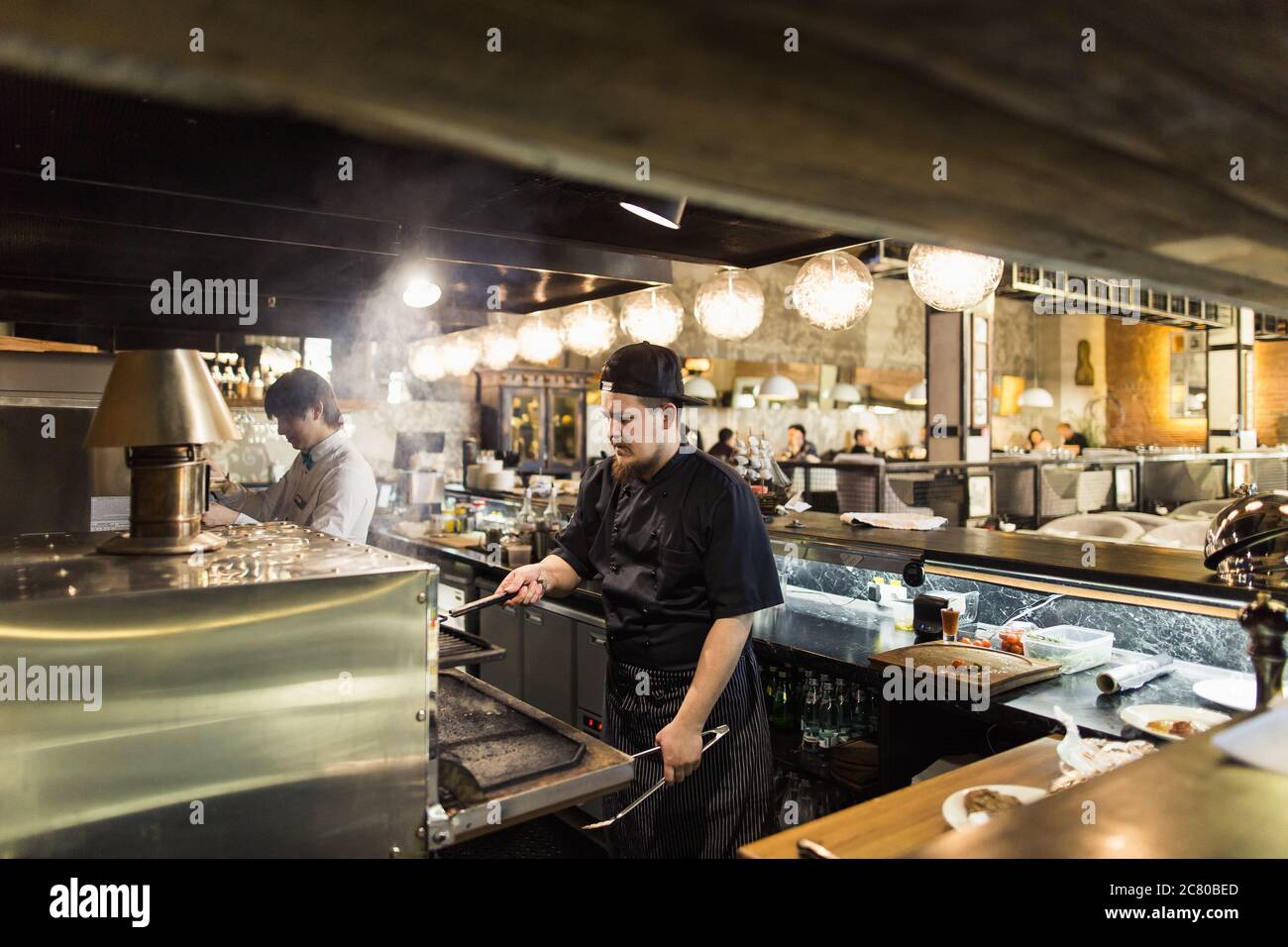 Man grilling meat on barbecue grill. Chief grilling to perfection Stock ...