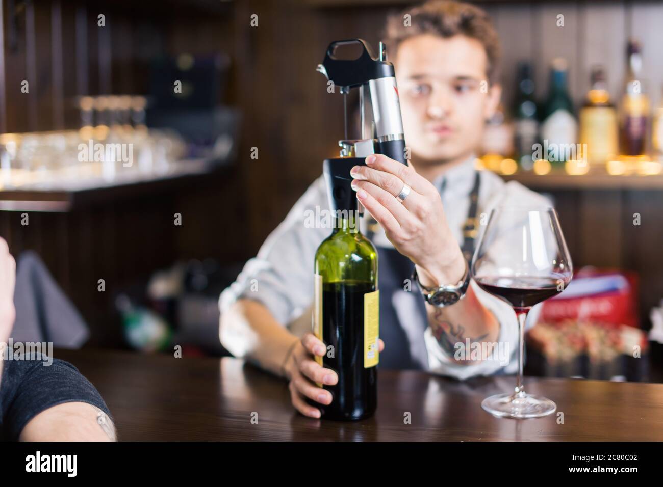 Sommelier opening wine bottle in the wine cellar Stock Photo - Alamy