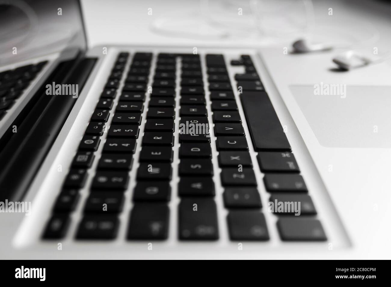 Top view of the keyboard of the laptop on white Desk with headphones ...