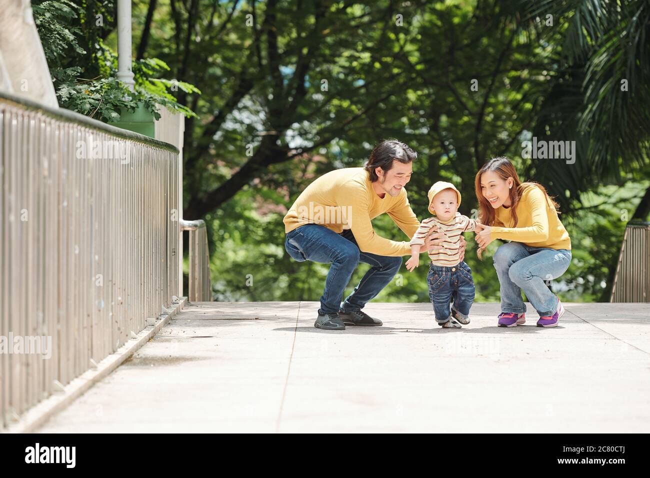 Happy young parents trying to catch their child who is trying to run ...