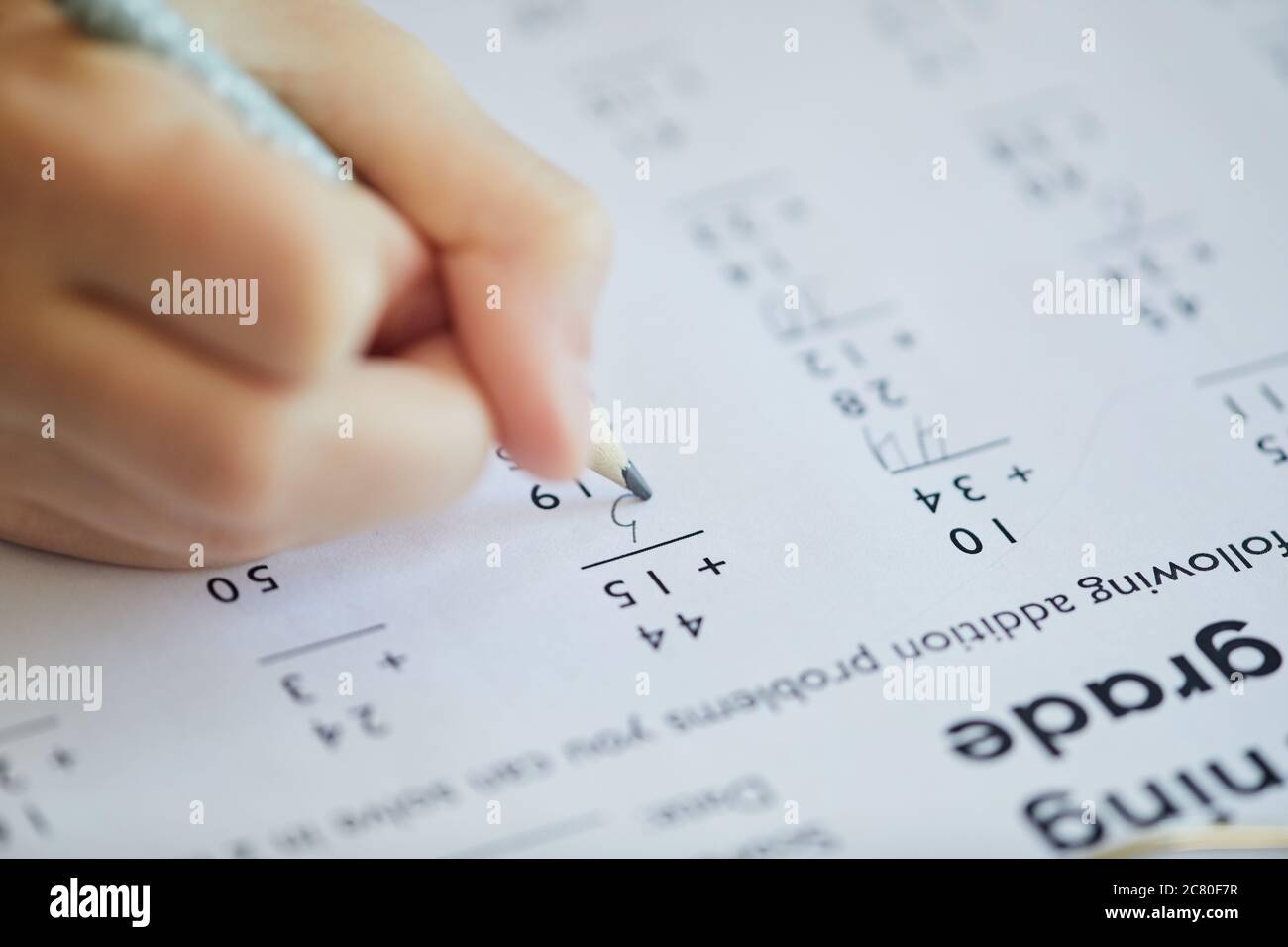 Extreme close up of unrecognizable child doing math test for online ...